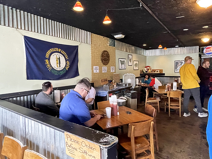 Kentucky pride on display alongside tables where barbecue dreams come true. In this room, the state flag watches over some very satisfied citizens.