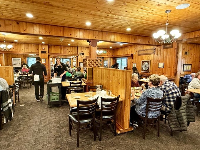 The dining room hums with the symphony of satisfied customers, wooden dividers creating intimate spaces for serious eating business.