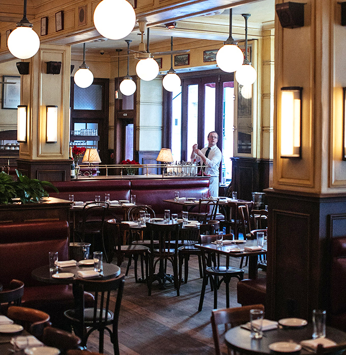 The dining room glows with that magical amber light that makes everyone look like they're starring in a Woody Allen film set in Paris.