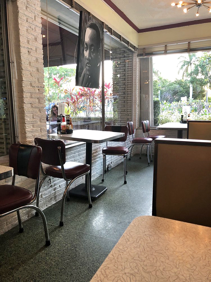 Exposed brick walls, classic diner chairs, and thoughtfully curated artwork create a space that honors tradition while embracing contemporary sensibilities.