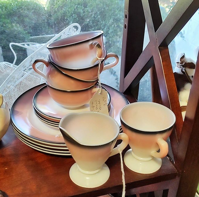 Delicate peach-hued dinnerware stacked with precision. These cups have probably witnessed thousands of conversations over morning coffee.