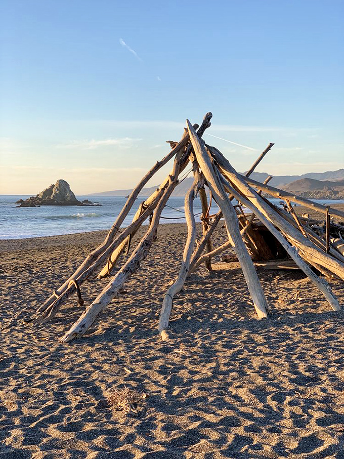 Beach architects at work&mdash;driftwood teepees stand as temporary monuments to human creativity and nature's generous building supplies. 