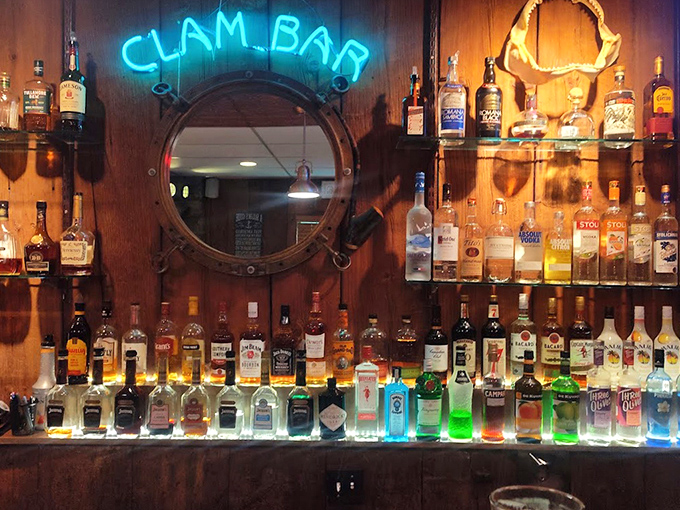 The "Clam Bar" sign glows like a lighthouse for thirsty sailors. Behind it, bottles stand at attention, ready for duty.