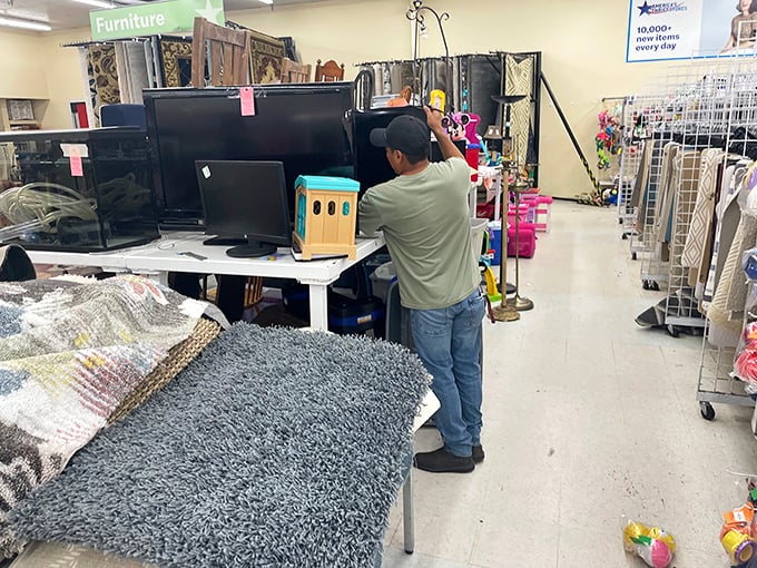 An employee carefully arranges electronics for display. Today's castoffs become tomorrow's vintage tech for collectors and practical users alike.