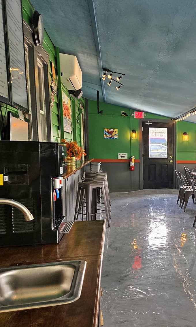 Where industrial meets cozy. The interior's thoughtful lighting and green walls create an atmosphere that makes even waiting for takeout pleasant.