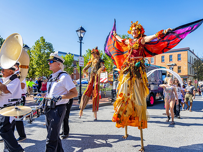 Festival performers transform Baltimore streets into living art, proving that sometimes the most magical urban renewal comes with stilts, wings, and a healthy dose of imagination.
