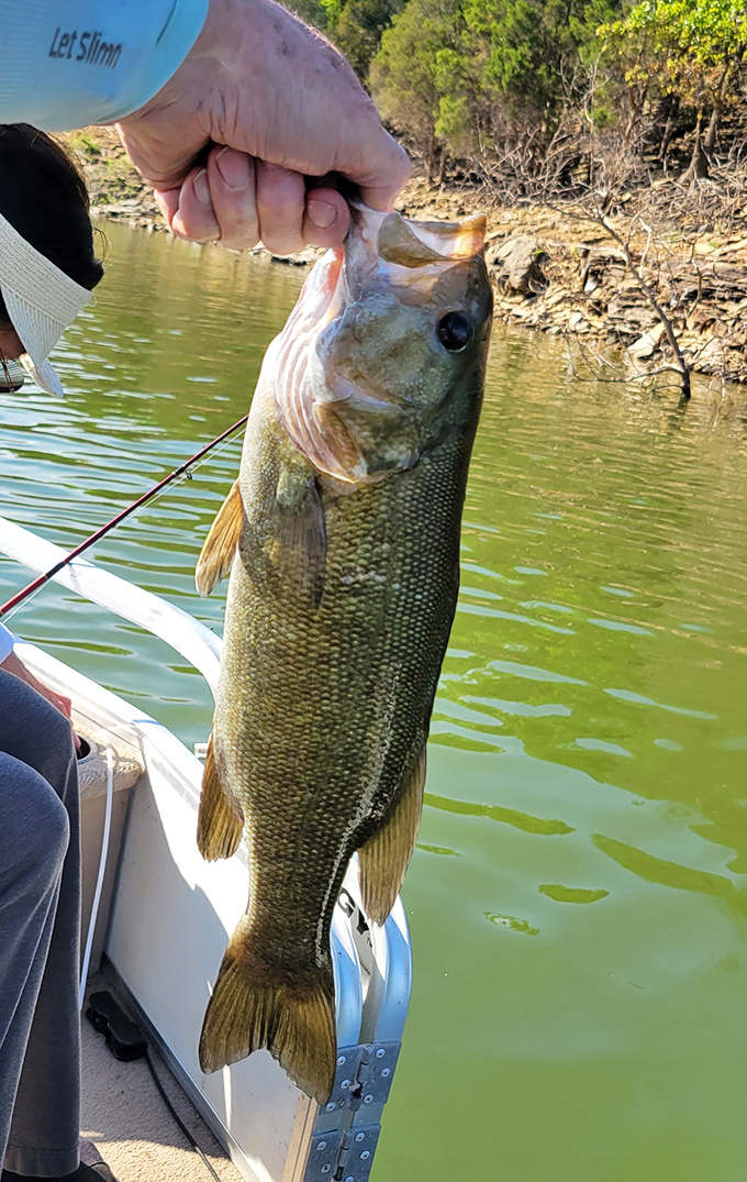 "Just another day at the office," said no bass fisherman ever. That smile says weekend victory, that fish says dinner.