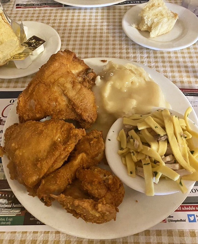 Fried chicken so perfectly golden it deserves its own Instagram account, accompanied by buttery noodles and potatoes drowning happily in gravy.
