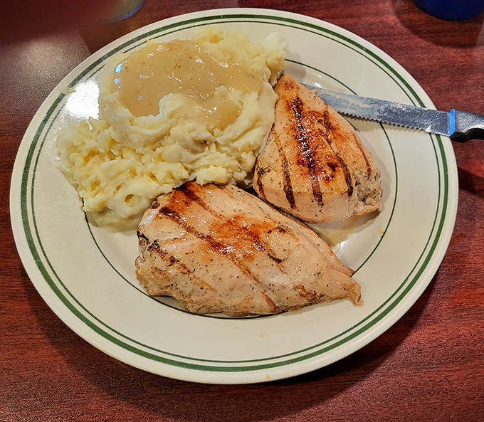 Grilled chicken breasts with grill marks so perfect they could be in a food photography textbook, alongside creamy mashed potatoes.