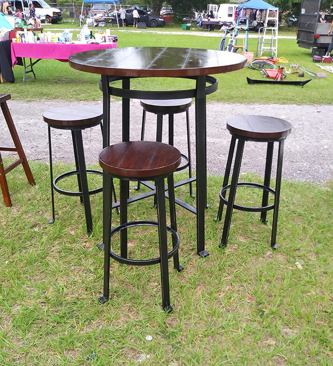 This bar-height table set waits patiently in the grass, dreaming of future dinner parties and morning coffees on someone's patio.