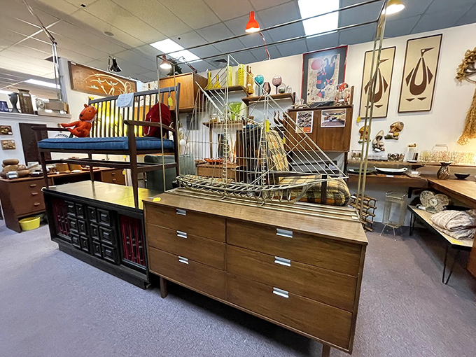 Mid-century furniture arranged like a Mad Men set waiting for Don Draper. That brass ship sculpture? Pure conversation-starting gold.