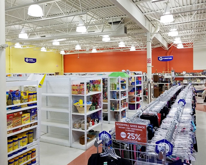 Vibrant color-blocked walls create distinct shopping zones while overhead signs guide the quest. The thrift store equivalent of a treasure map leads to unexpected discoveries.