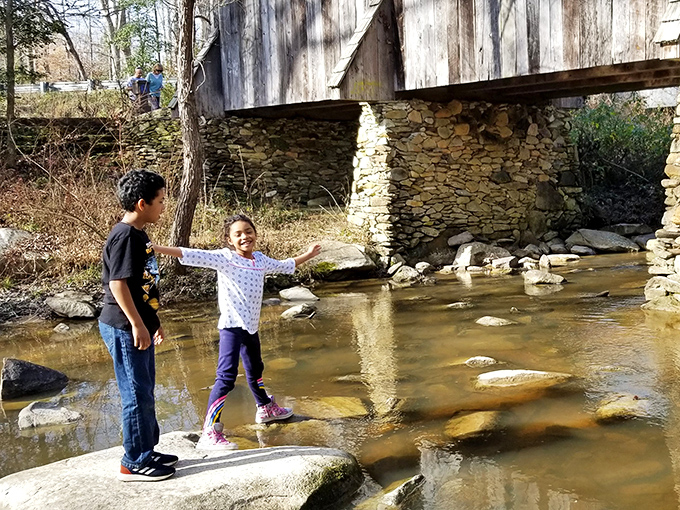 Some places just beg for childhood exploration. These young adventurers discover the simple joy of stone-hopping in the shallow waters beneath history's watchful gaze.