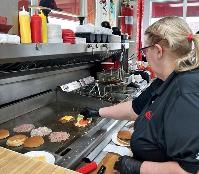 The choreography of the flat-top grill&mdash;where thin patties transform into crispy-edged wonders under the watchful eye of experienced hands.