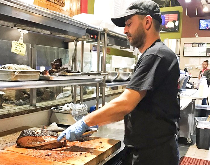 The kitchen pass&mdash;where barbecue dreams materialize. That cornbread waiting patiently is about to make someone's day exponentially better.