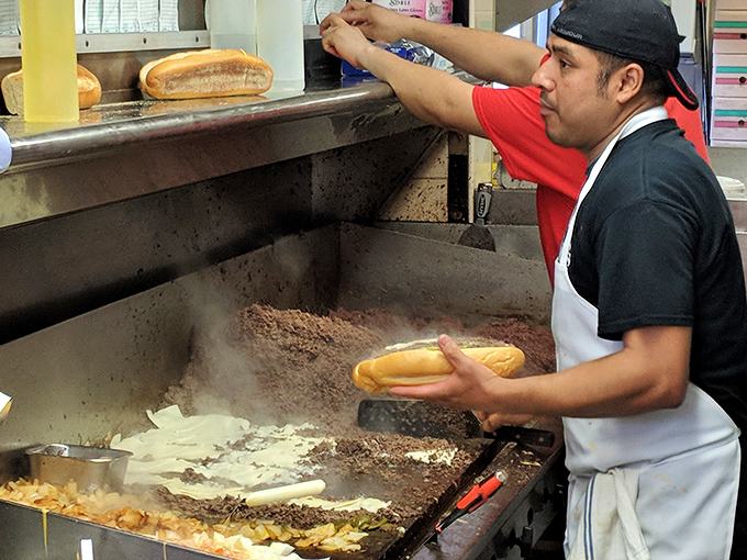 The maestro at work, transforming simple ingredients into legendary sandwiches. That sizzling grill has probably seen more drama than a soap opera.