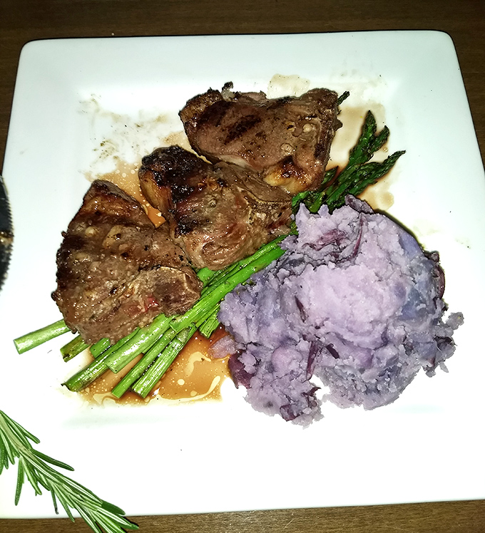 Lamb chops nestled against purple mashed potatoes like a culinary odd couple that somehow works brilliantly together.