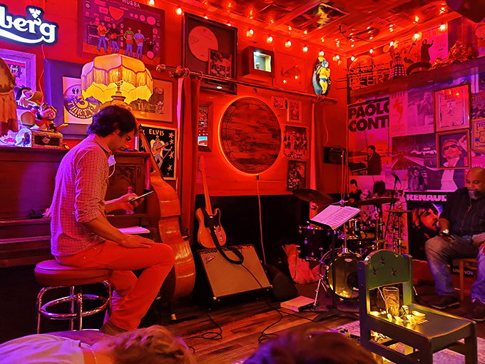 Live music transforms dinner into an event—jazz notes floating through the red-hued air as patrons unconsciously tap their feet between bites.