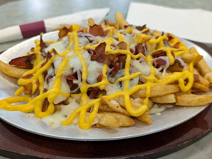 Loaded fries: where cheese, bacon, and potatoes hold their annual summit meeting. The yellow mustard zigzag is just showing off at this point.