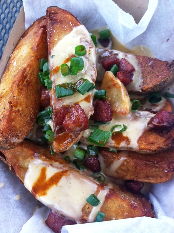 Potato wedges living their best life under a blanket of cheese, bacon, and green onions. Comfort food that hugs you from the inside.