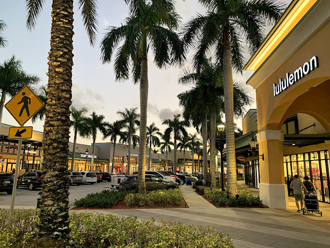 Lululemon's storefront basks in the golden Florida sunset, surrounded by royal palms that seem to stand at attention for arriving shoppers.