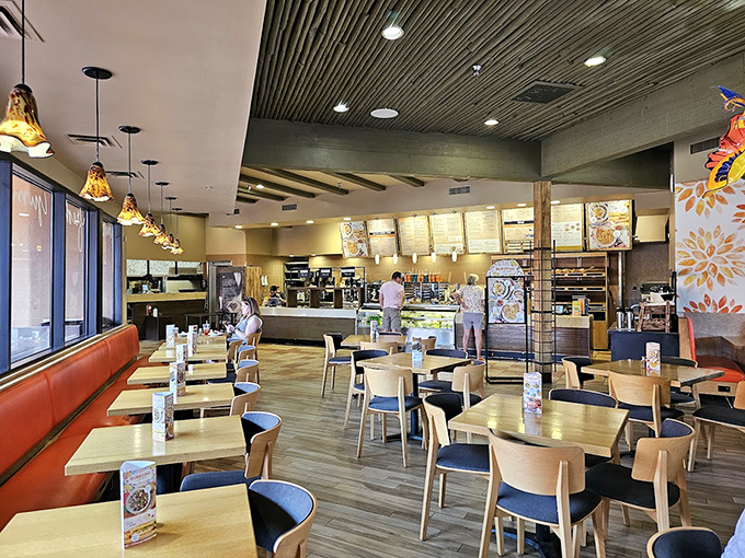 Clean lines, warm wood, and that signature orange seating create a space where you'll want to linger long after your meal.