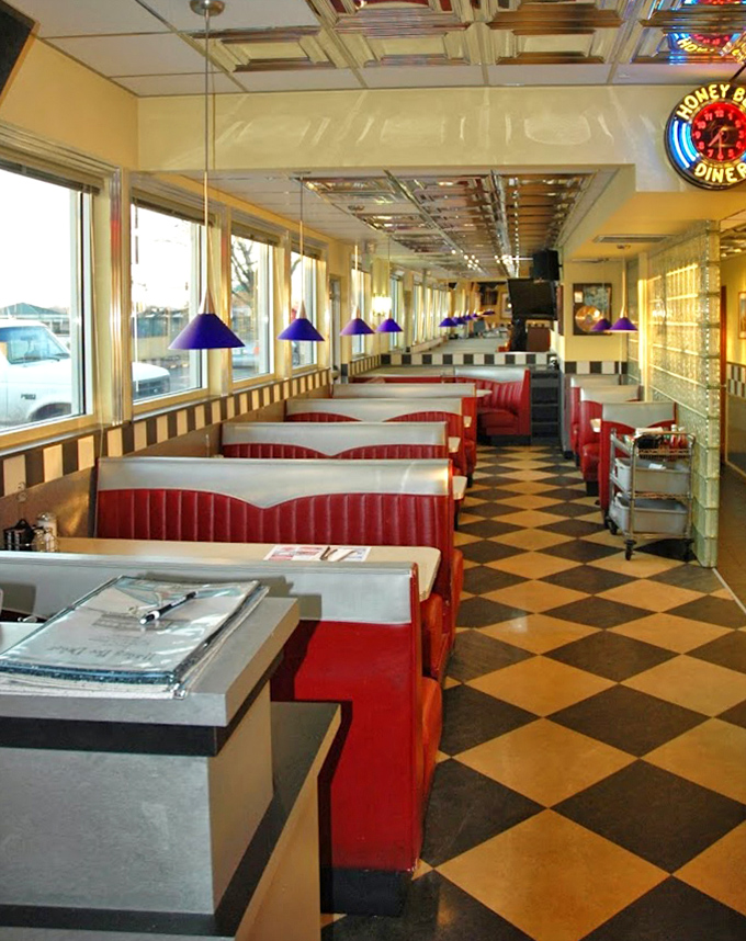 Purple pendant lights hover above red booths like friendly UFOs, illuminating a diner straight from the American dream.