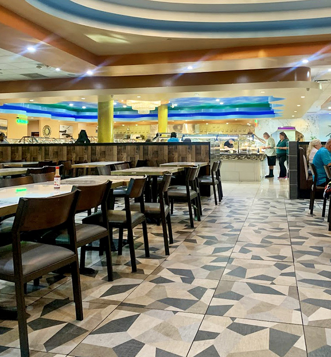 The dining room's blue ceiling rings and geometric floor create an unexpected oasis of style. This isn't your 1990s strip mall buffet experience.