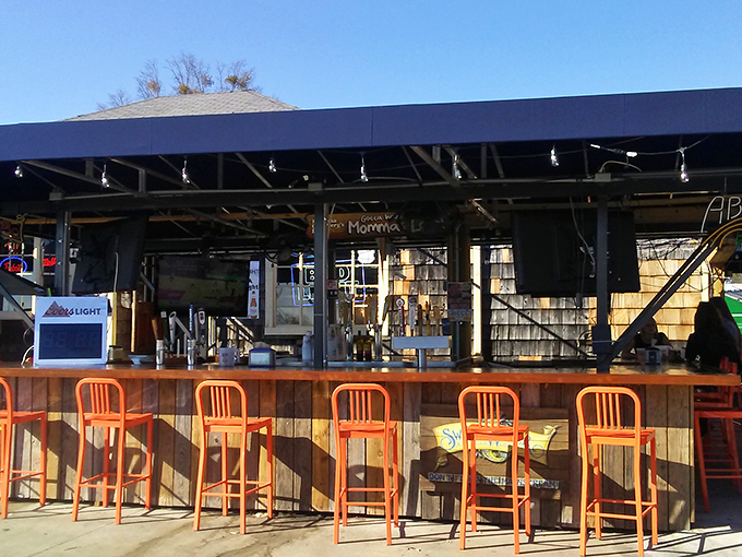 Orange bar stools stand at attention like loyal soldiers guarding the outdoor bar—your next refreshing beverage is just a perch away.