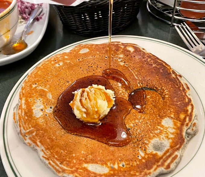 Pancake perfection in its natural habitat&mdash;golden, fluffy, and swimming in syrup like it's training for the breakfast Olympics.