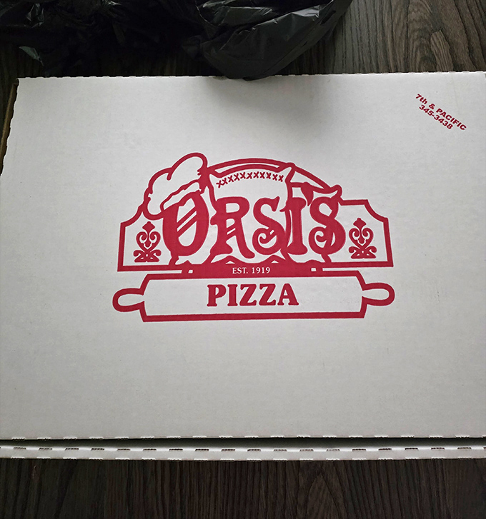 That red logo on the pizza box is basically a guaranteed happiness delivery system disguised as simple cardboard packaging.
