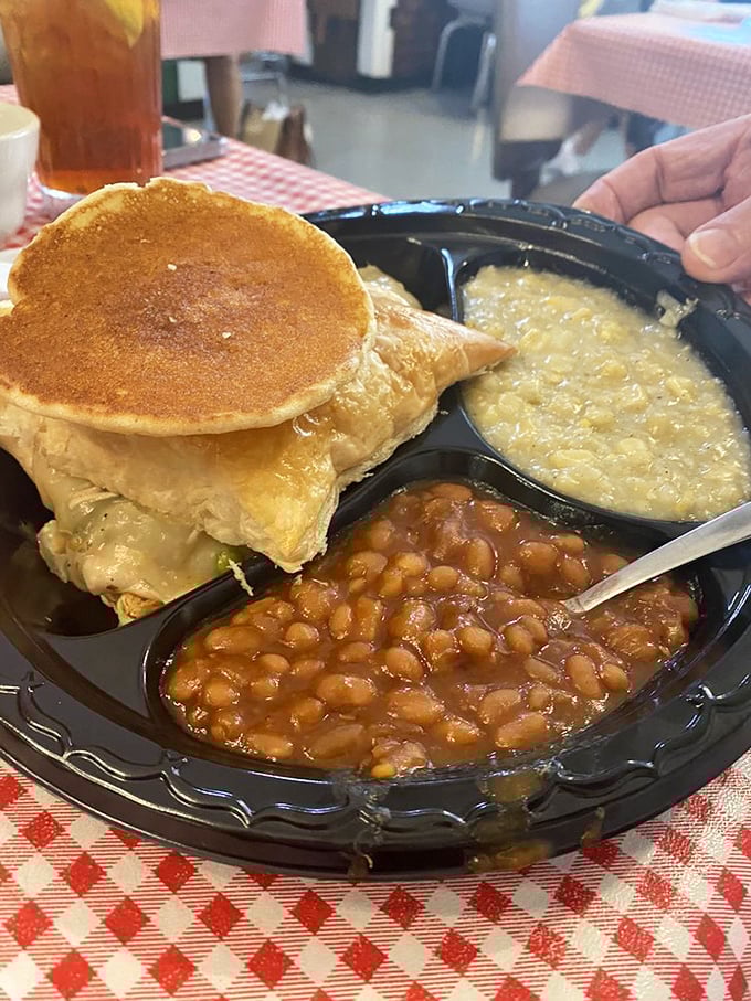 Breakfast perfection: golden pancakes with the holy trinity of Southern sides&mdash;grits, baked beans, and enough syrup to make dentists nervous.