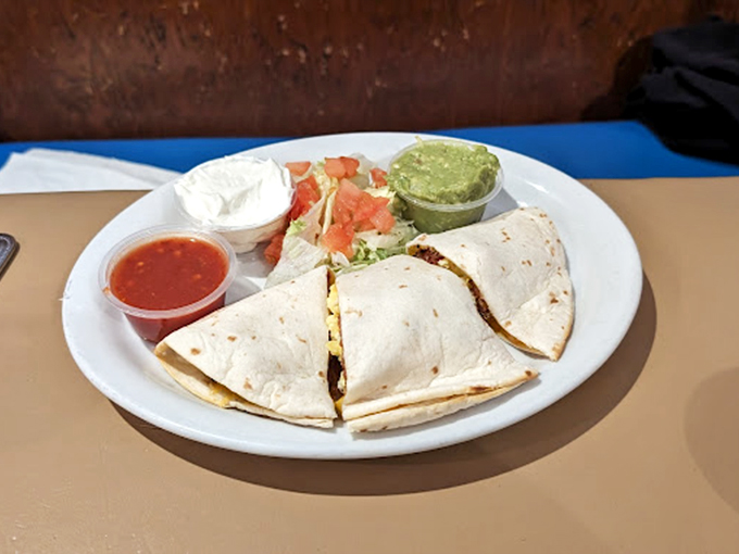 A quesadilla plated with the colorful trio of salsa, guacamole, and sour cream. Like a mariachi band, these flavors perform in perfect harmony.
