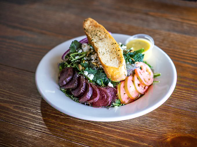 A salad so vibrant it could power a small city. Beets and greens playing nicely together with a slice of bread standing guard.