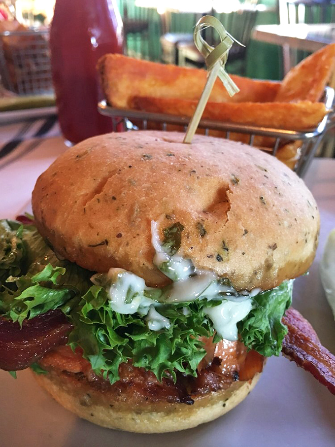 A burger that demands to be photographed before being devoured. That herb-flecked bun isn't just pretty – it's the perfect delivery system for deliciousness.