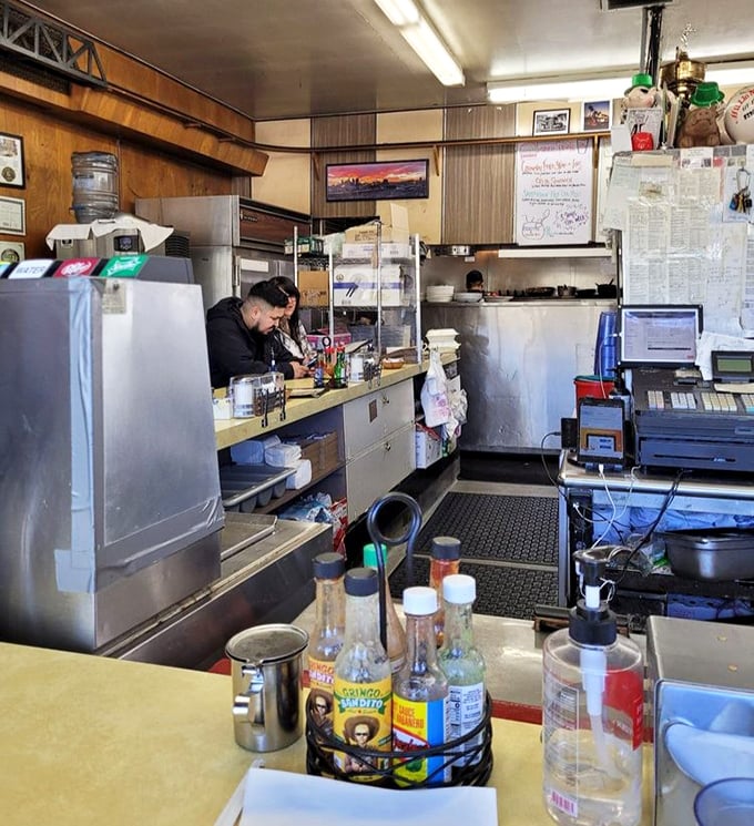 The service counter tells stories through condiment caddies and well-worn surfaces that have supported more elbows than an orthopedist's office.