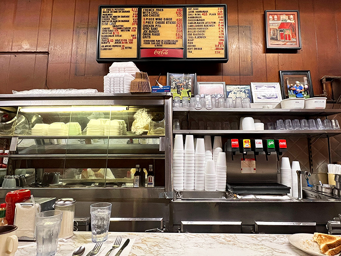 The counter view invites you to a front-row seat for culinary theater, where short-order cooking becomes performance art under the warm glow of vintage lighting.