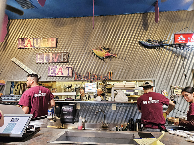 Behind the counter where culinary magic happens, with the "LAUGH LOVE EAT" mantra serving as both decoration and mission statement.