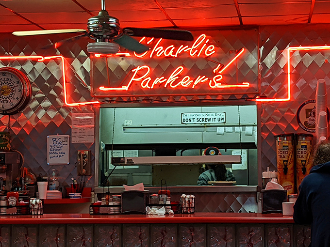Behind that glowing neon sign, kitchen wizards perform breakfast magic while a sign warns "Don't Screw It Up!"