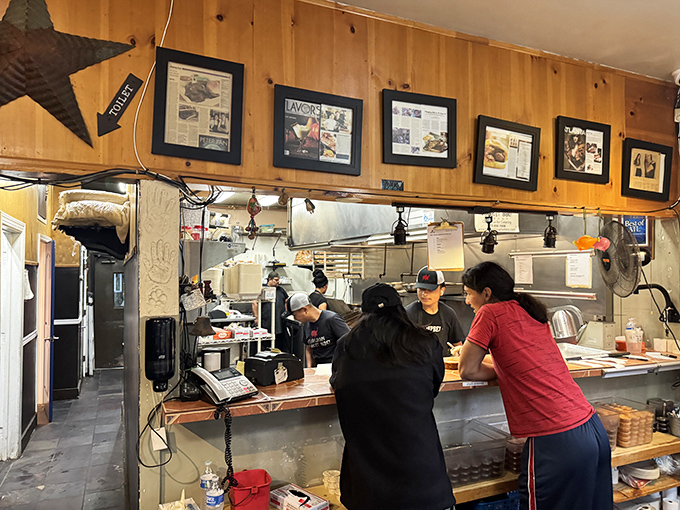 Behind the counter where dreams come true. The open kitchen design lets you witness the choreography of smoke, meat, and expertise.