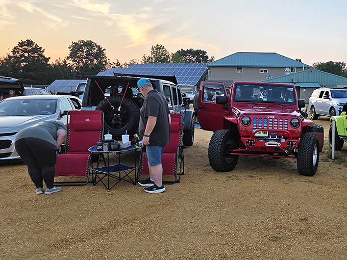 Tailgating meets cinema as patrons create their outdoor living rooms. That red Jeep owner clearly understands drive-in culture perfectly.
