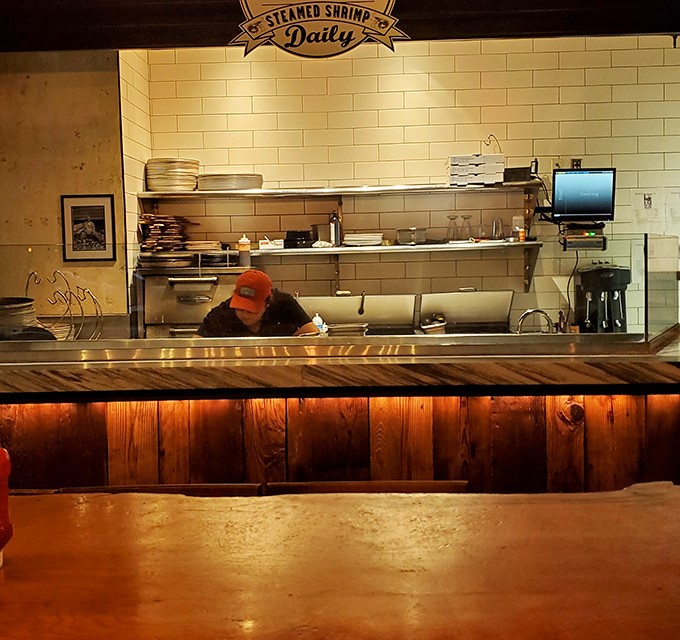 The open kitchen design lets you watch culinary magic happen in real time, with the "Steamed Shrimp Daily" sign promising fresh seafood treasures.