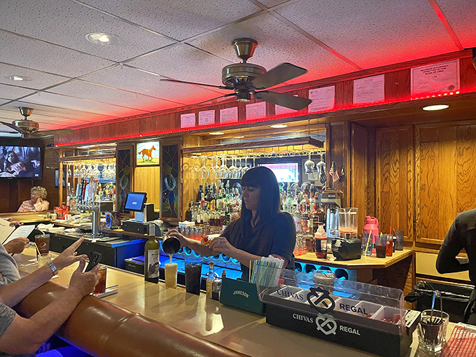 Behind the bar, where magic happens in liquid form. The neon glow and well-stocked shelves promise the perfect pairing for whatever barbecue treasure you've ordered.