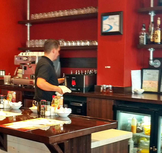 A staff member works his morning magic behind the counter, probably wondering why everyone's so chipper before their first caffeine hit.
