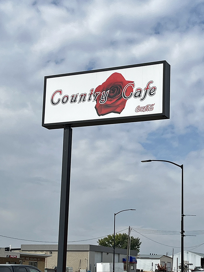 The roadside sign stands tall against Dakota skies, a beacon guiding hungry travelers toward breakfast salvation.
