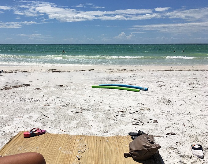 The essentials of beach happiness: a mat, a noodle, and absolutely nowhere important to be. This is what vacation philosophers call "perfect simplicity."