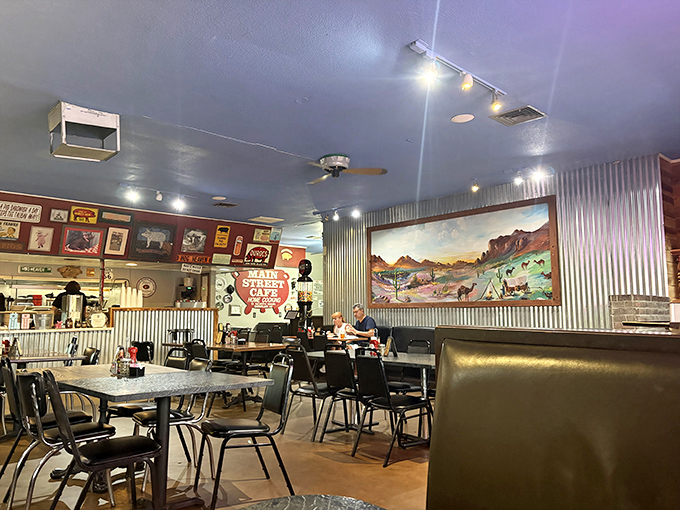 The dining room where strangers become friends over shared BBQ enthusiasm. That desert landscape mural reminds you you're in Arizona, not Kansas City.
