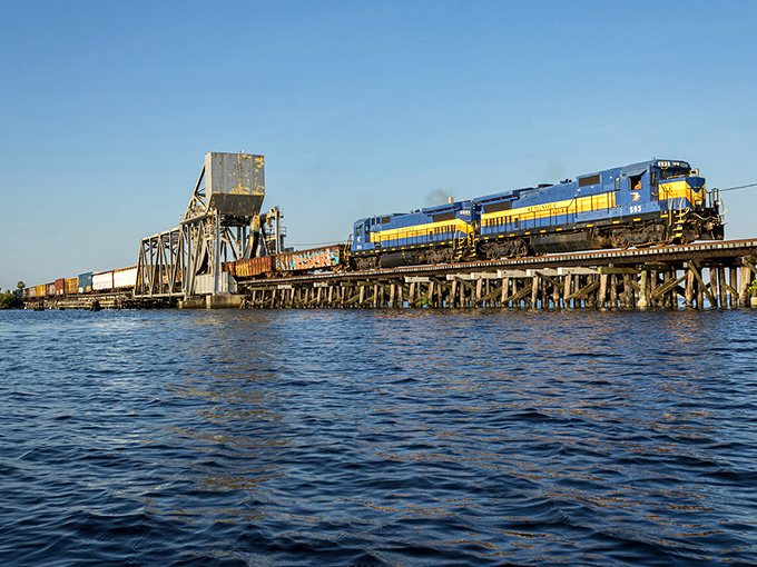 The railway's bridge crossing creates that rare Instagram moment where engineering and nature achieve perfect harmony.