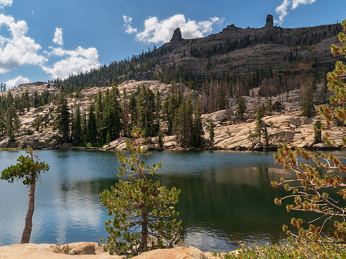 Alpine lake perfection framed by weathered granite and stoic pines. Mother Nature's masterclass in landscape composition.