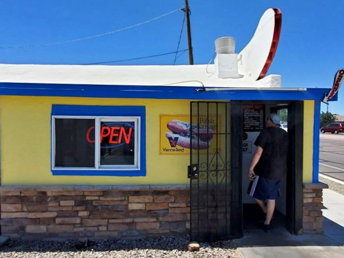 Higley Hot Dog Hut's sunny yellow exterior matches the cheerful experience inside. Small building, big flavors, happy customers.